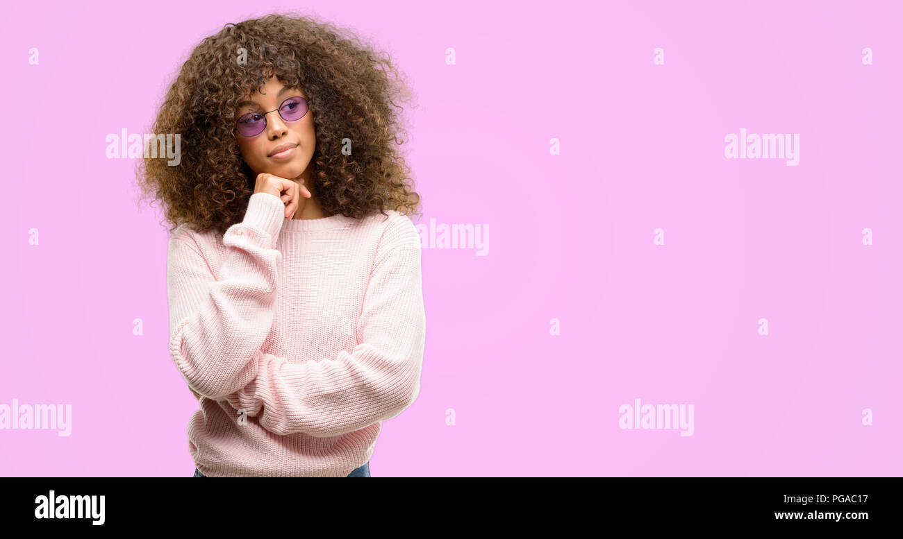 African american woman wearing a pink sweater serious face thinking ...