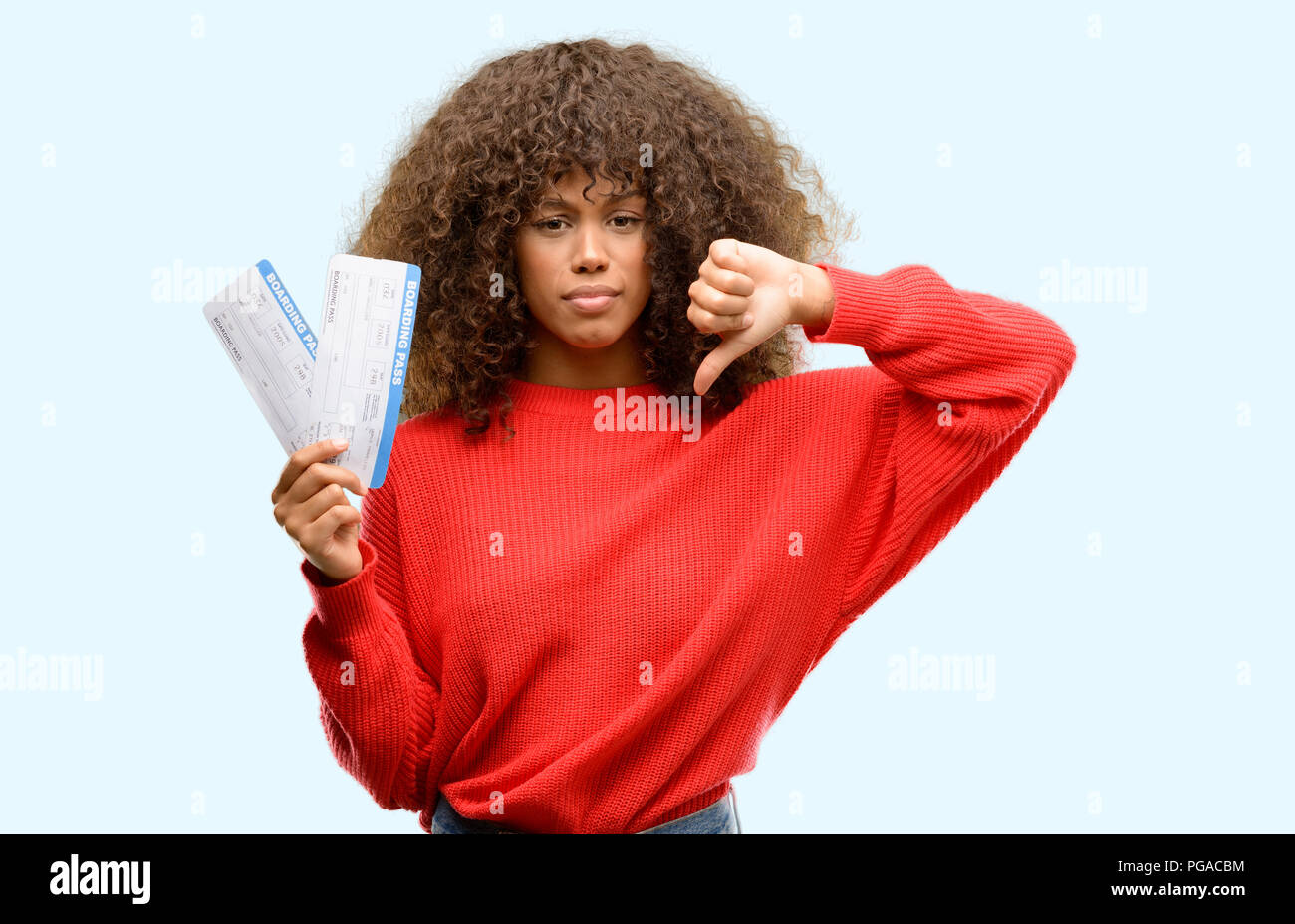African american woman holding airline boarding pass tickets with angry ...