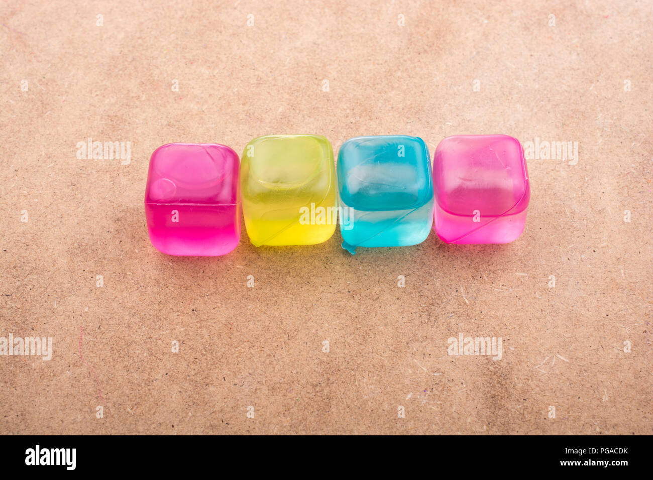 Fake colorful ice cubes on a brown background Stock Photo - Alamy