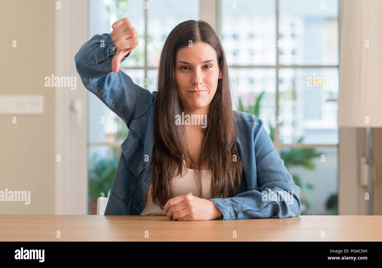 Young beautiful woman at home with angry face, negative sign showing ...