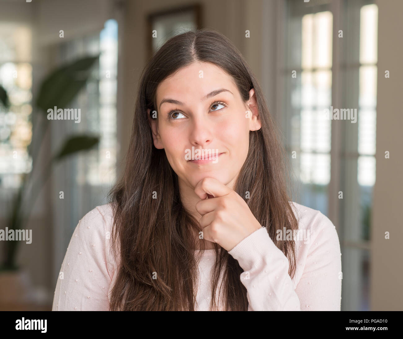 Young beautiful woman at home serious face thinking about question ...