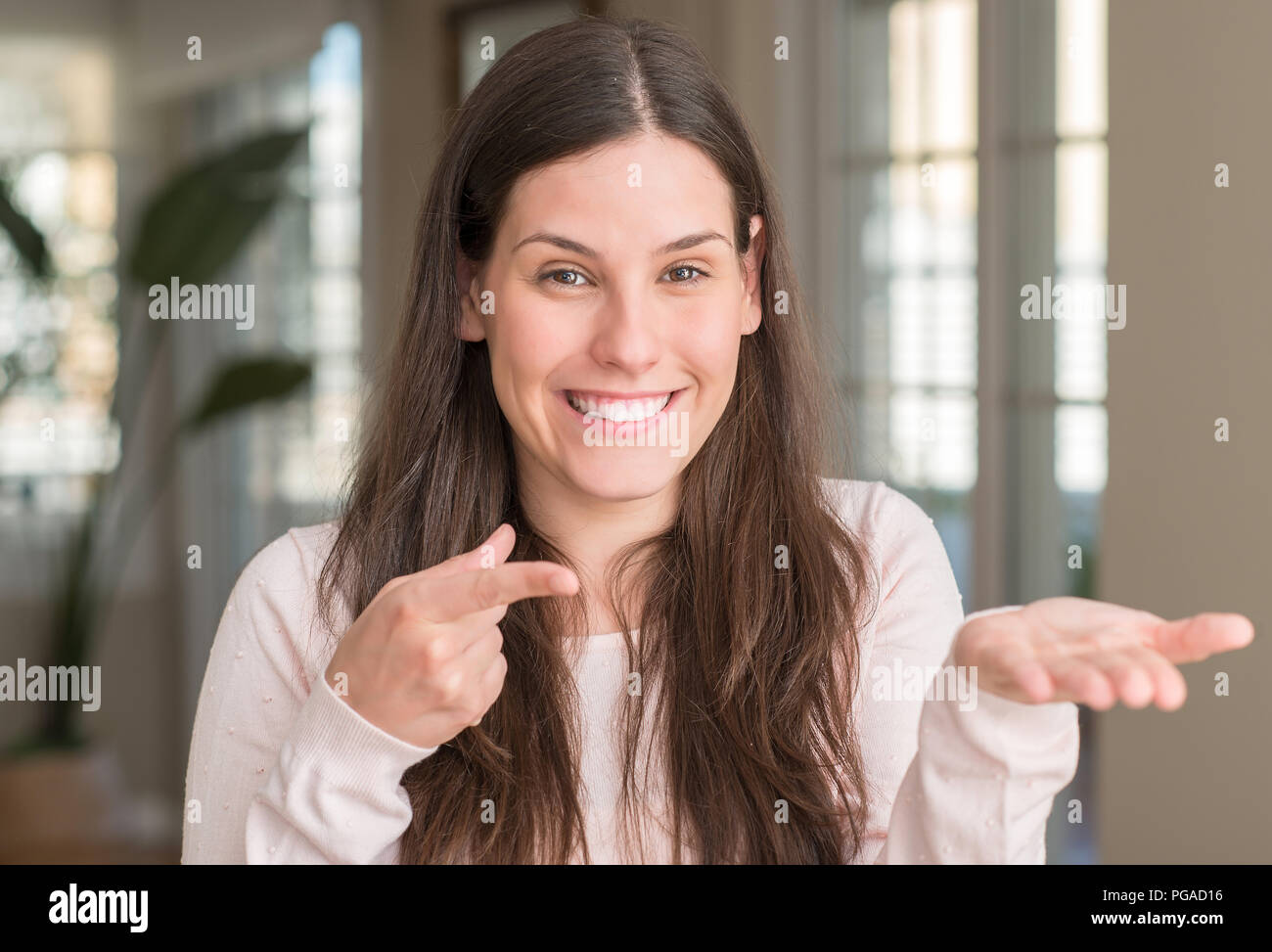 Young beautiful woman at home very happy pointing with hand and finger ...