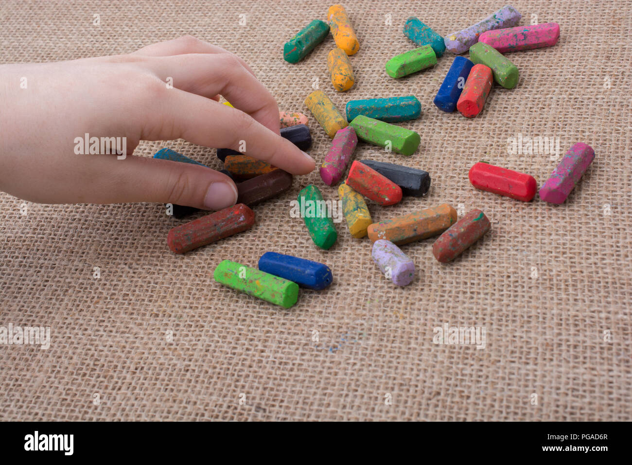 Used color crayons and a hand holding one Stock Photo - Alamy