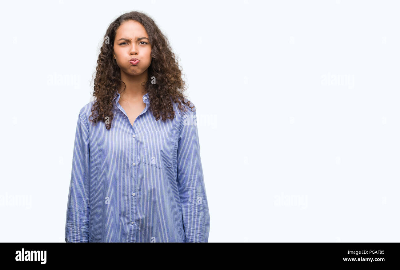 Young hispanic business woman puffing cheeks with funny face. Mouth ...