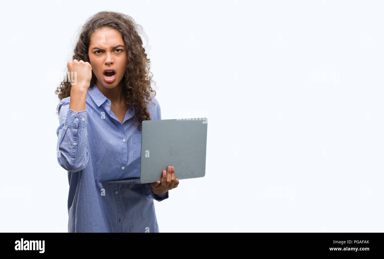 Young hispanic woman holding computer laptop annoyed and frustrated ...
