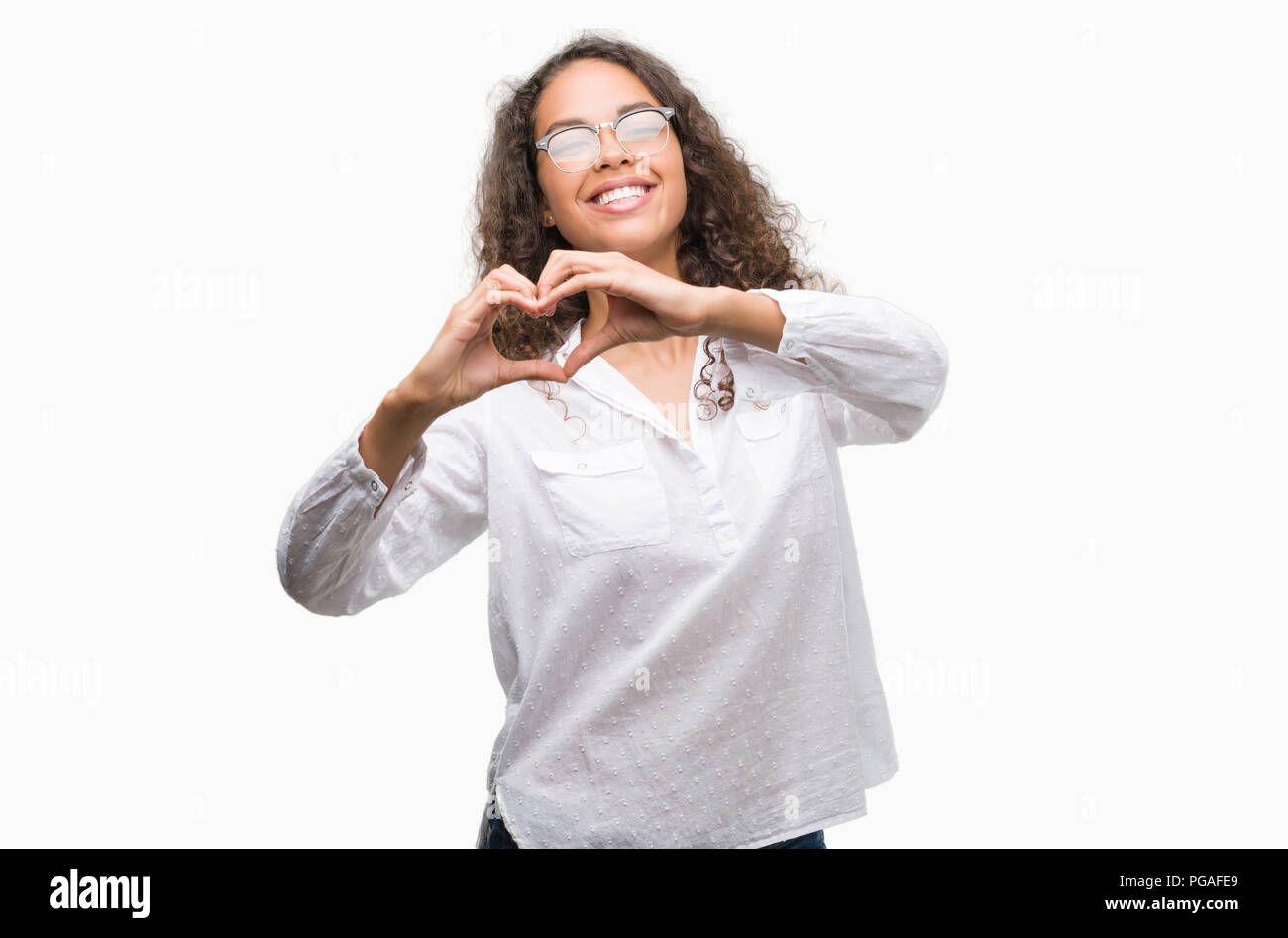 Beautiful young hispanic woman smiling in love showing heart symbol and ...