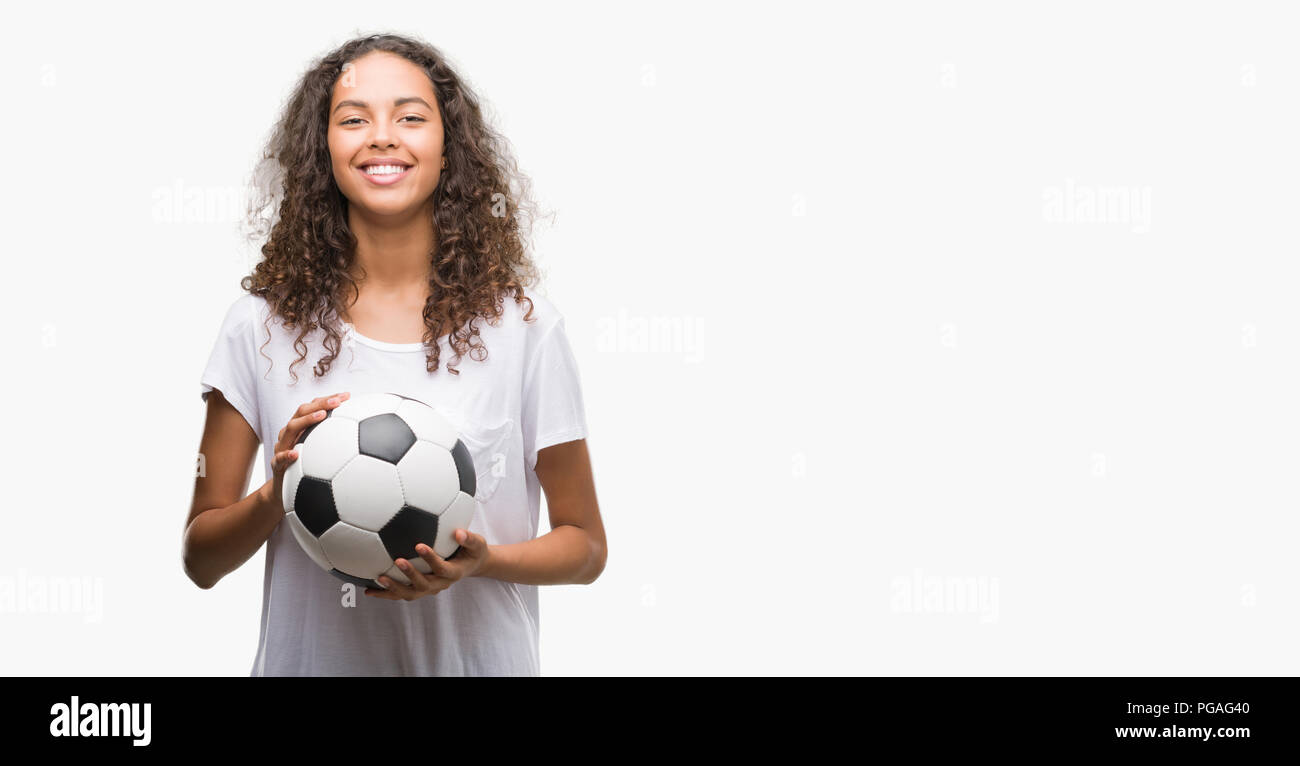 Young hispanic woman holding soccer football ball with a happy face ...