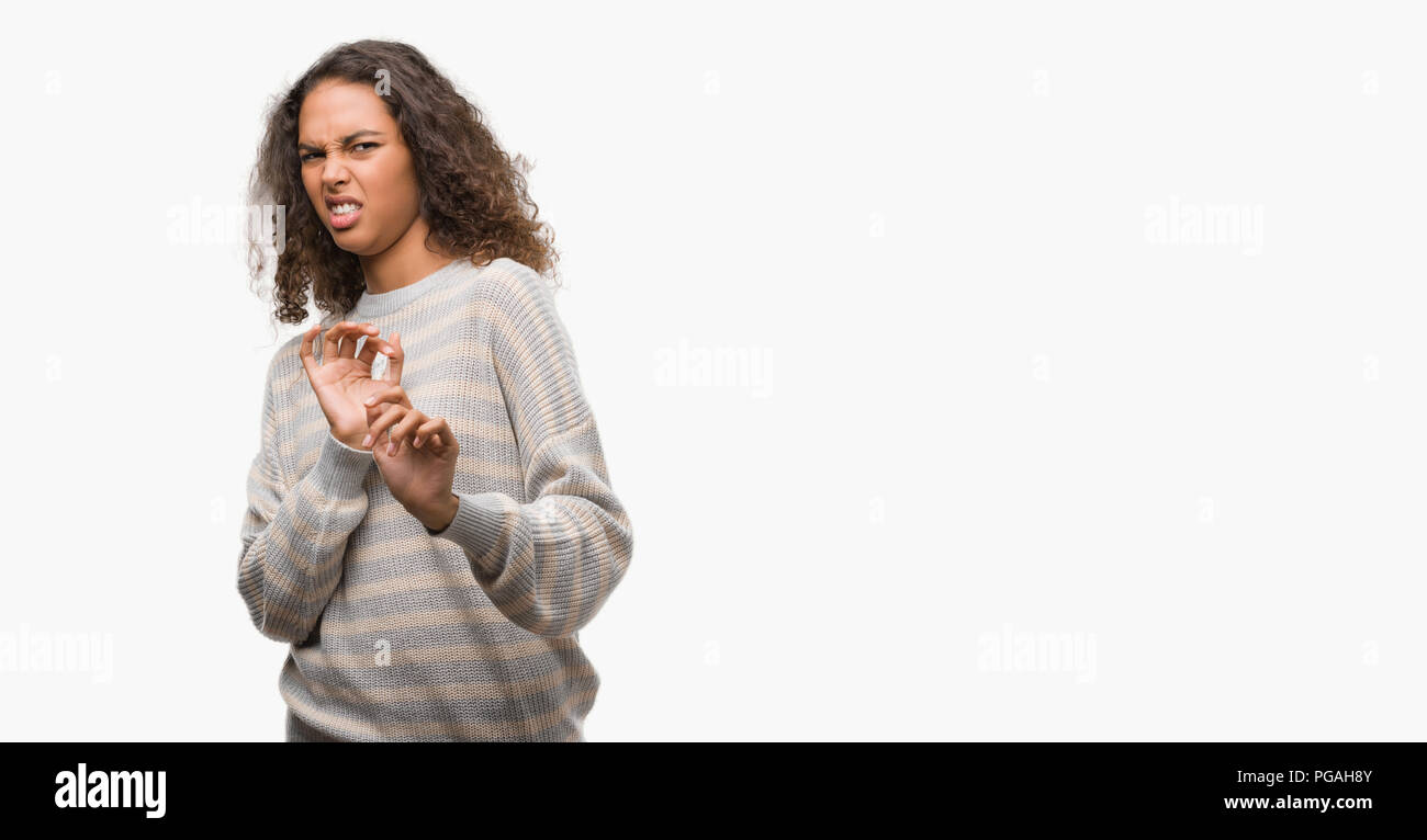 Beautiful young hispanic woman wearing stripes sweater disgusted ...