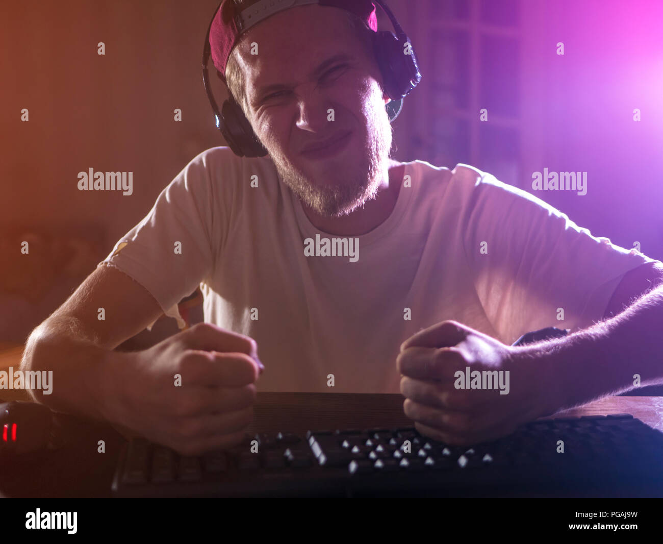 portrait of young bearded male gamer playing video game in the night ...