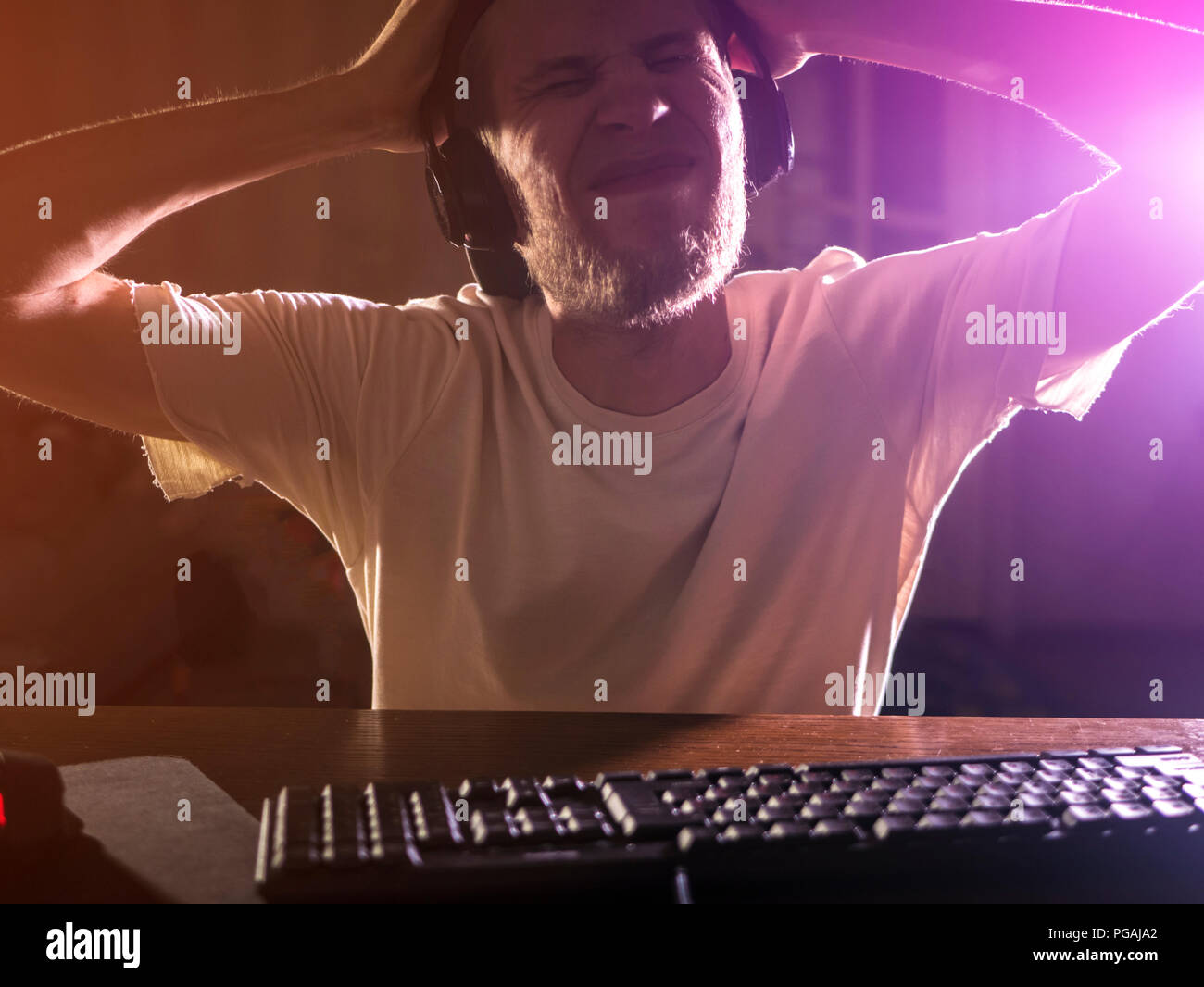 portrait of young bearded male gamer playing video game in the night ...