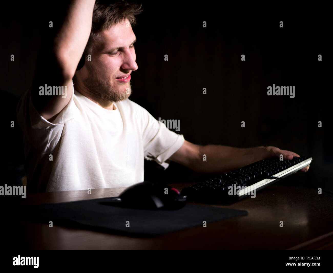 young mad crazy gamer breaking the keyboard playing video games on ...