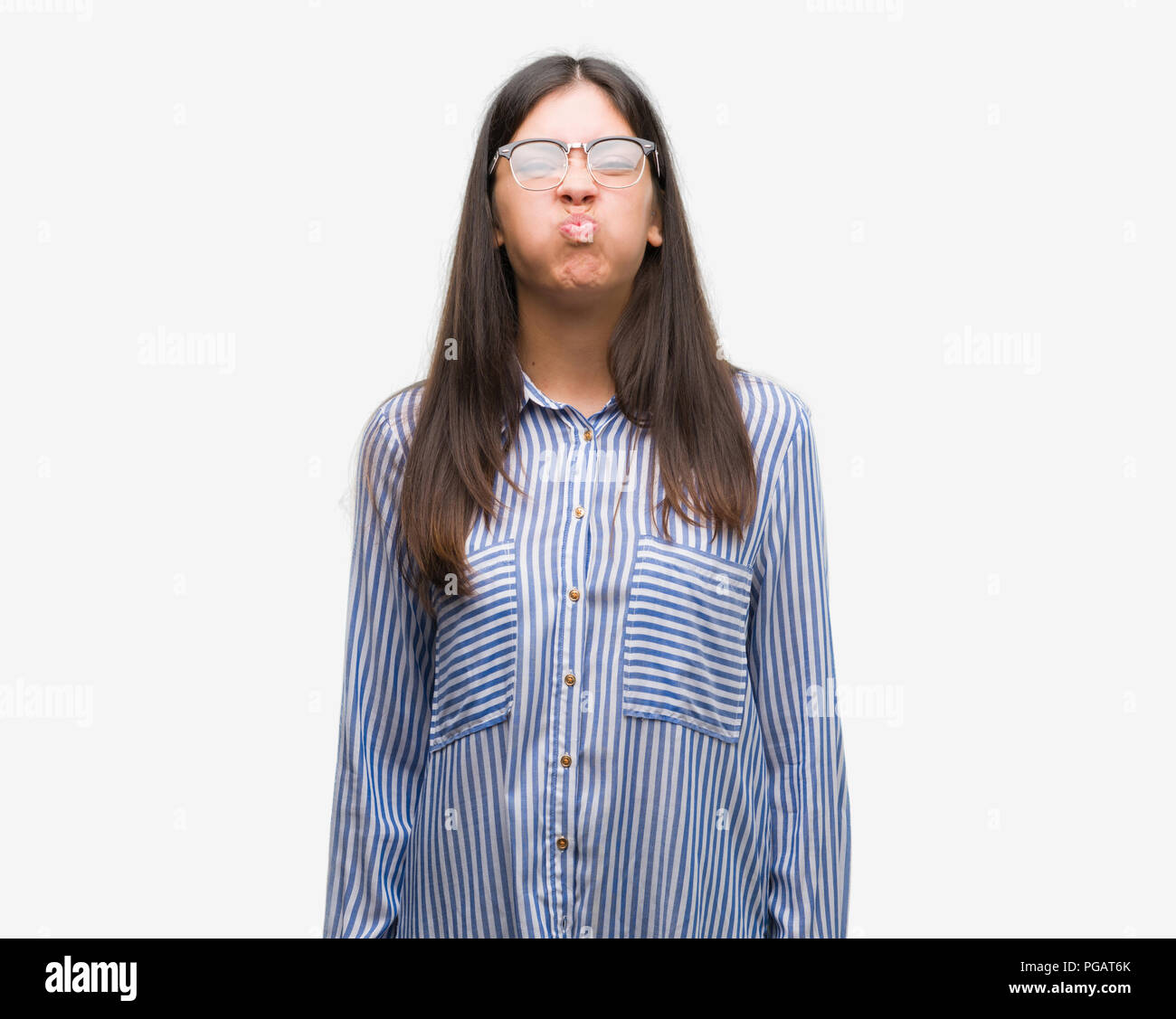 Young beautiful hispanic business woman puffing cheeks with funny face ...