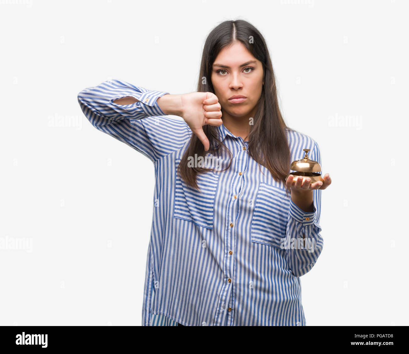 Young beautiful hispanic holding hotel ring bell with angry face ...