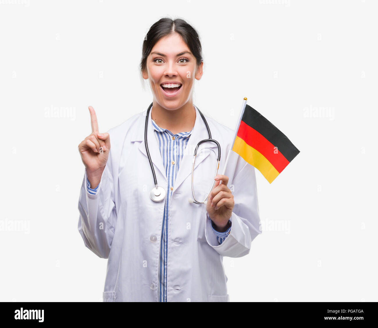 Young hispanic doctor woman holding flag of germany surprised with an ...