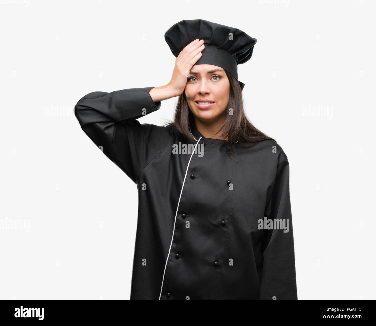 Young hispanic cook woman wearing chef uniform stressed with hand on ...
