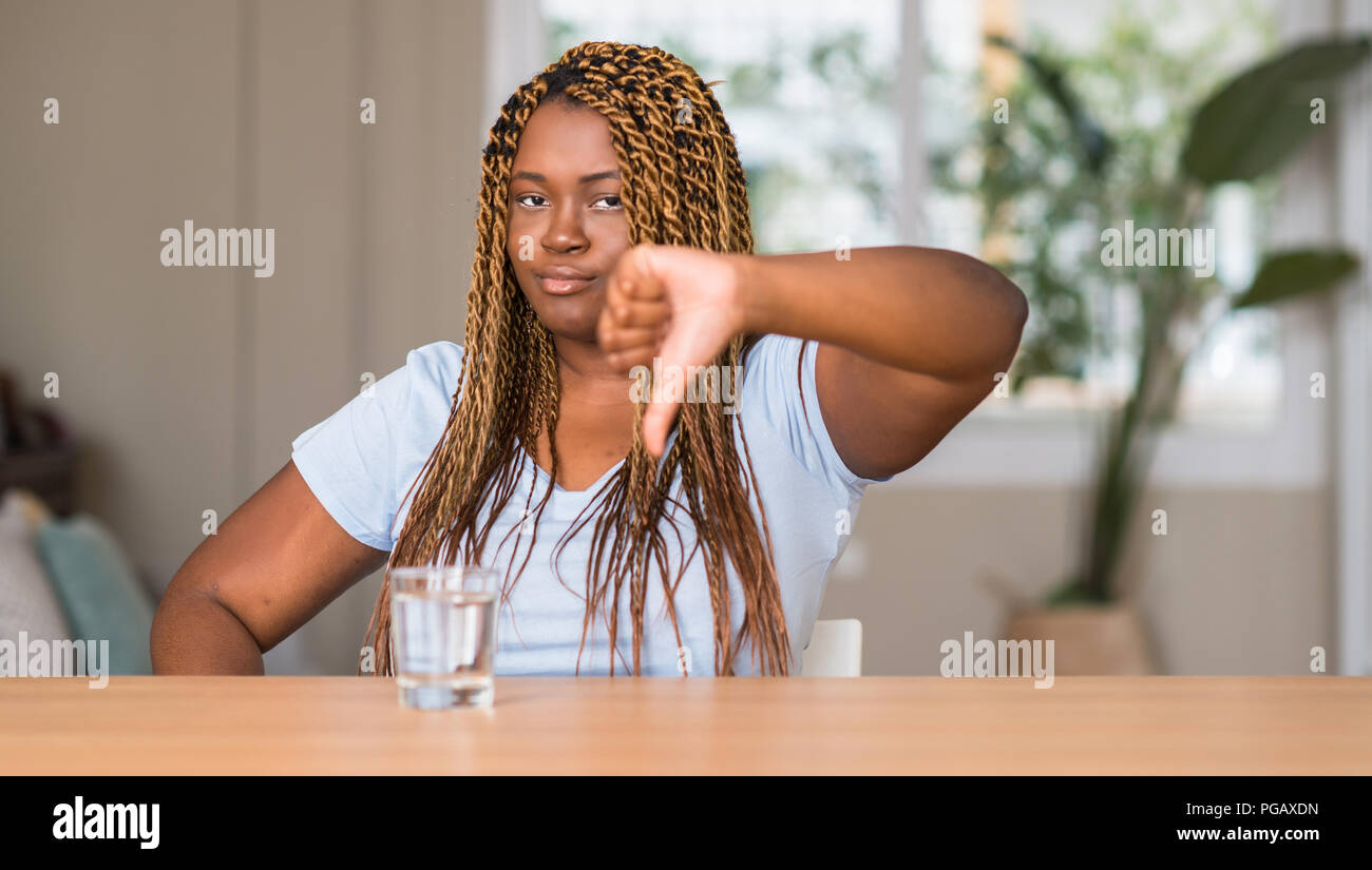 African american woman drinking water with angry face, negative sign ...