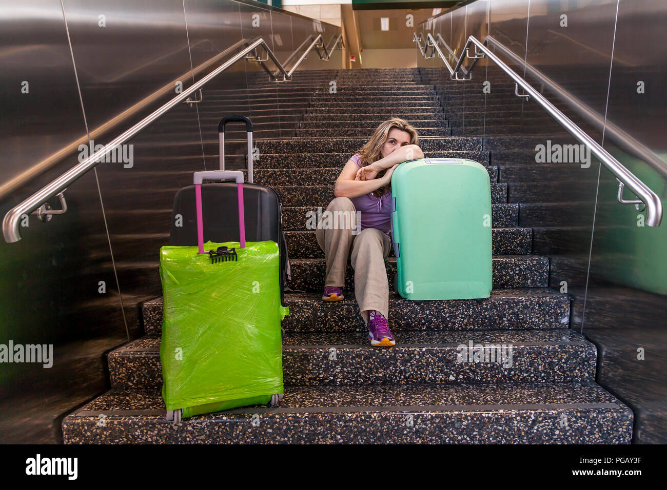 tired tourist traveler waiting sitting on the stairs with baggage at ...