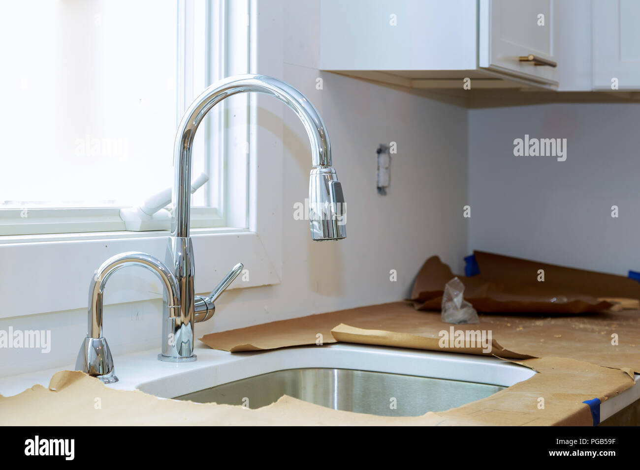 New modern white kitchen with built in chrome water tap Stock Photo - Alamy