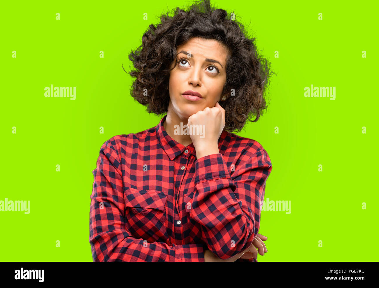 Beautiful arab woman thinking and looking up expressing doubt and ...