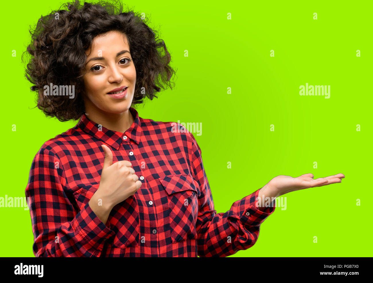 Beautiful arab woman thumb up holding something in empty hand and ...