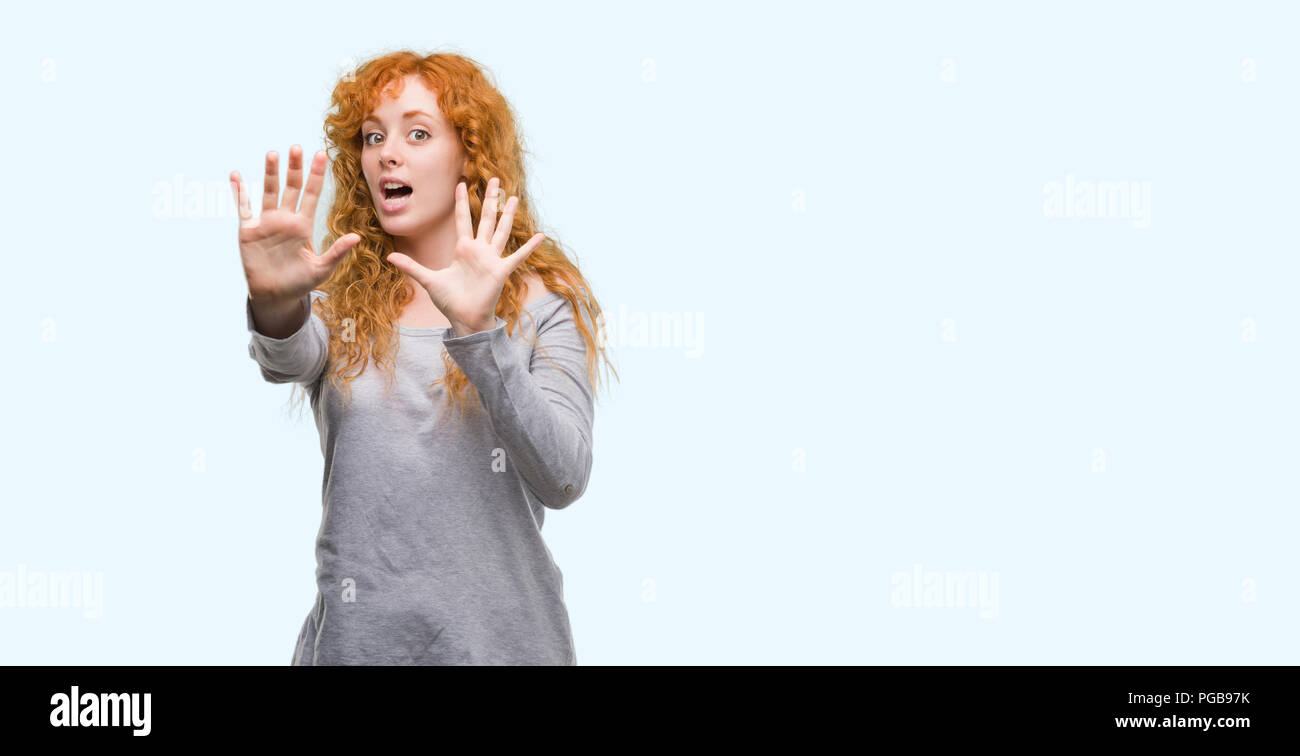 Young redhead woman afraid and terrified with fear expression stop ...