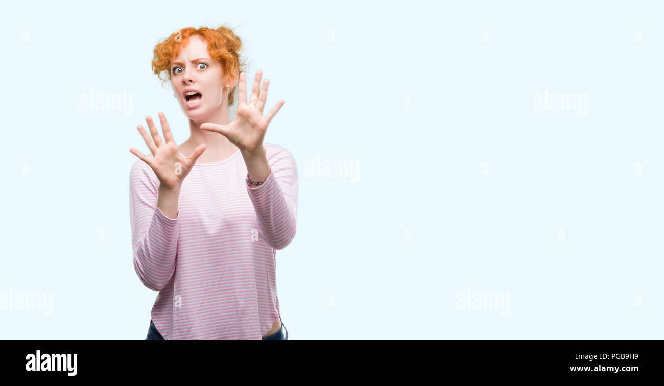 Young redhead woman afraid and terrified with fear expression stop ...