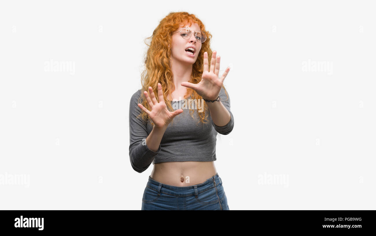 Young redhead woman afraid and terrified with fear expression stop ...