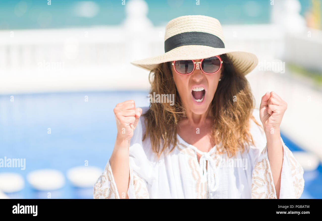 Middle age brunette woman by the swiming pool annoyed and frustrated ...