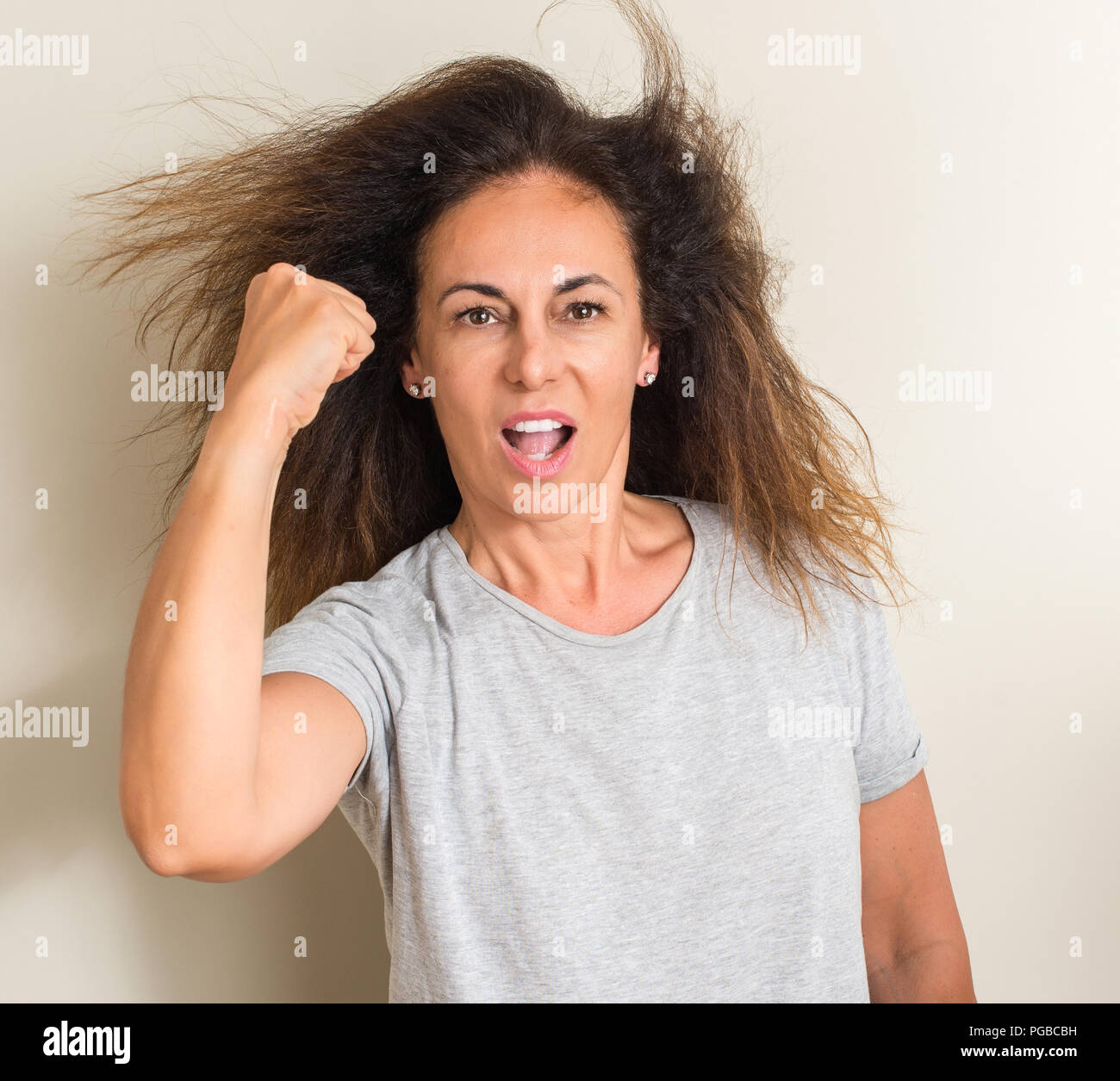 Curled hair brazilian woman annoyed and frustrated shouting with anger ...