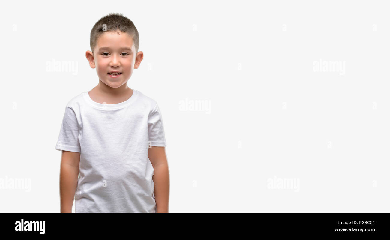 Dark haired little child with a happy face standing and smiling with a ...