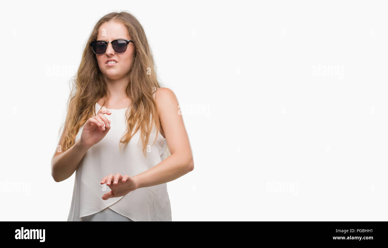 Young blonde woman wearing sunglasses disgusted expression, displeased ...