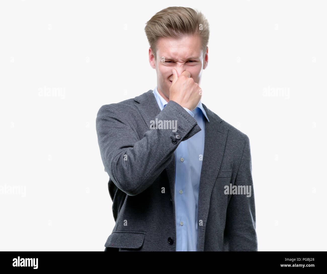 Young handsome blond business man smelling something stinky and ...