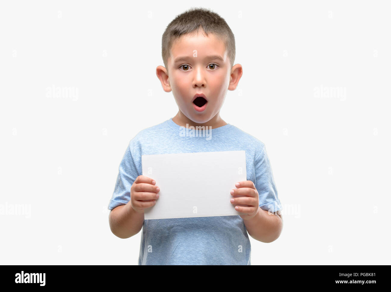 Dark haired little child holding a blank card scared in shock with a ...