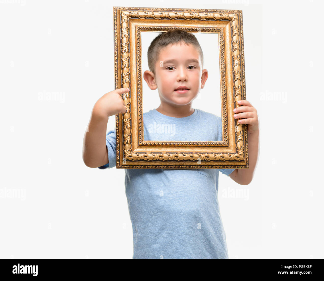 Dark haired little child holding frame very happy pointing with hand ...