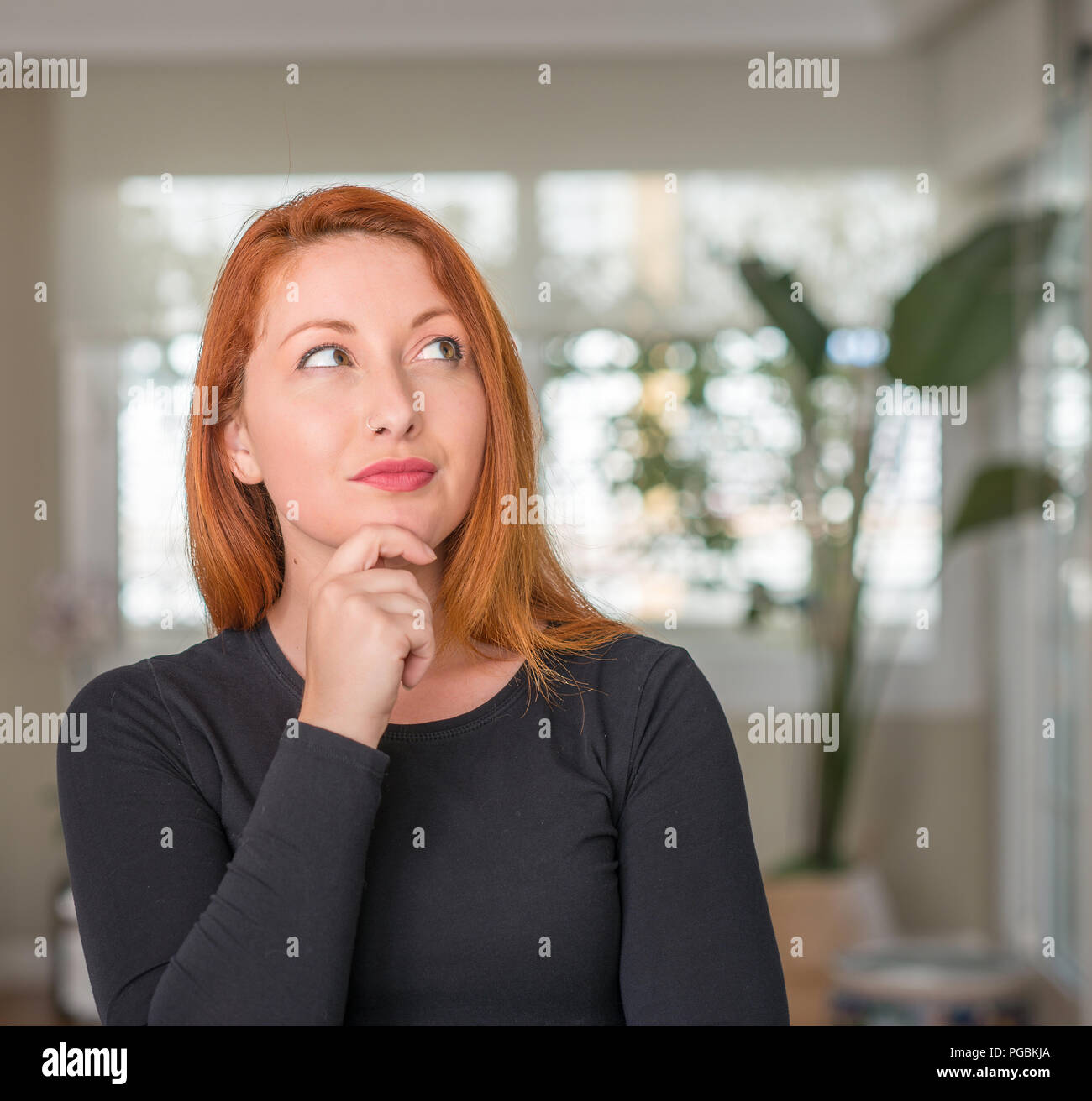 Redhead woman at home serious face thinking about question, very ...