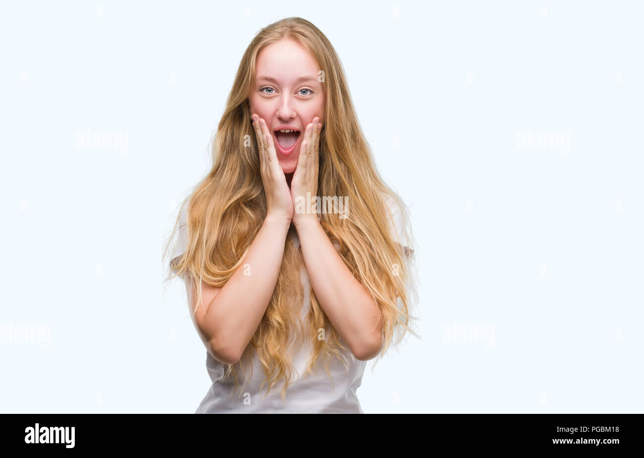 Blonde teenager woman scared in shock with a surprise face, afraid and ...
