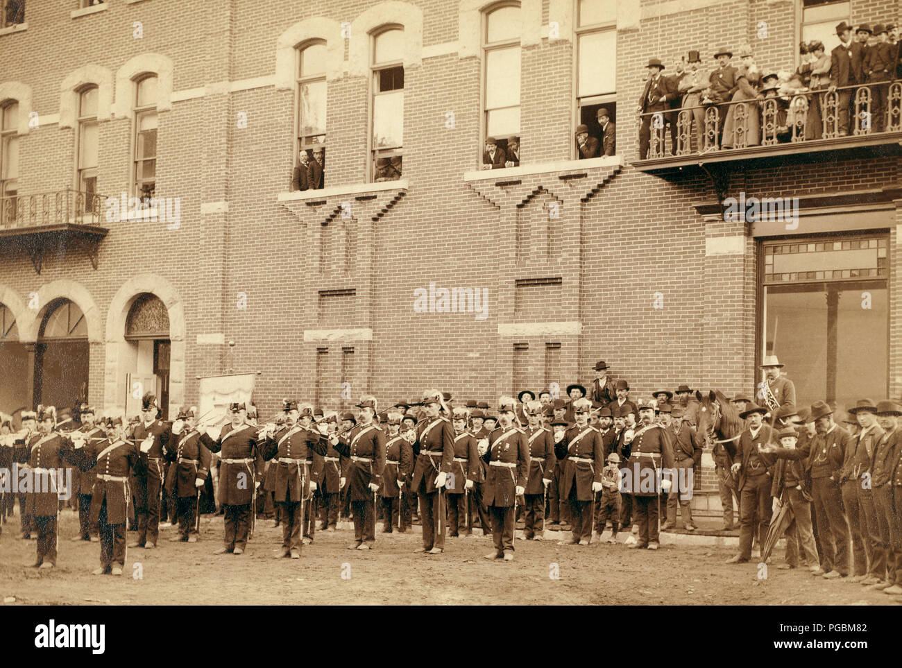 Group of uniformed men posing in front of a large brick building Stock ...