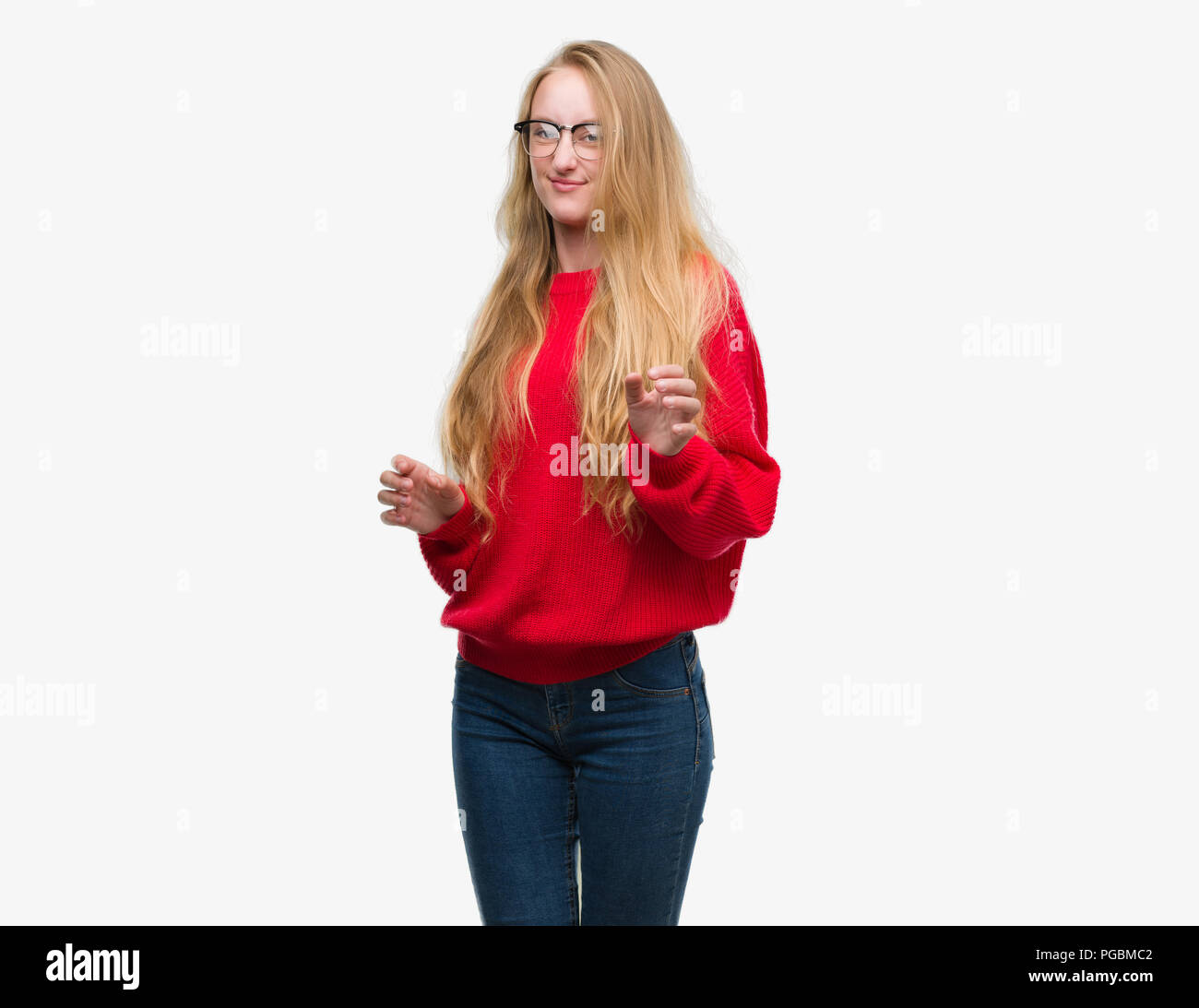 Blonde teenager woman wearing red sweater disgusted expression ...