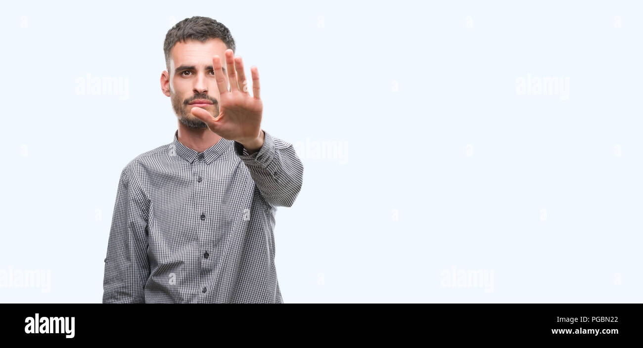 Young hipster man doing stop sing with palm of the hand. Warning ...