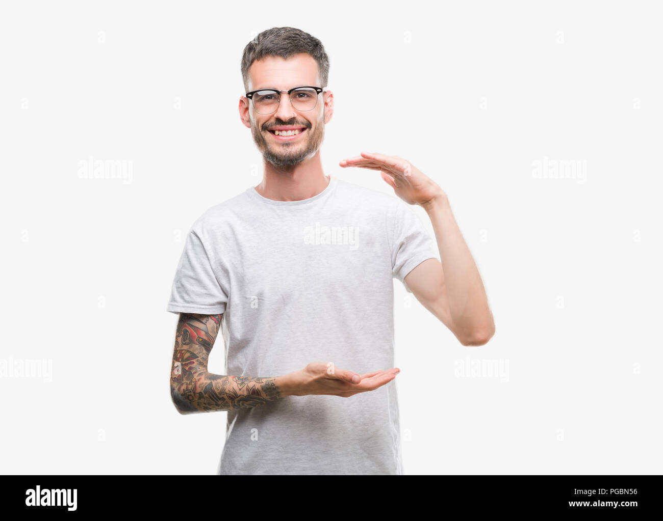 Young tattooed adult man gesturing with hands showing big and large ...