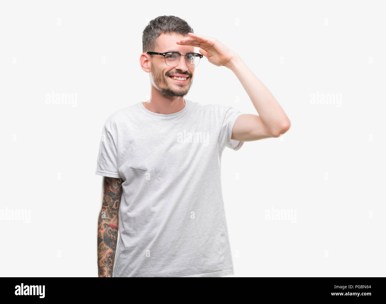 Young tattooed adult man very happy and smiling looking far away with ...