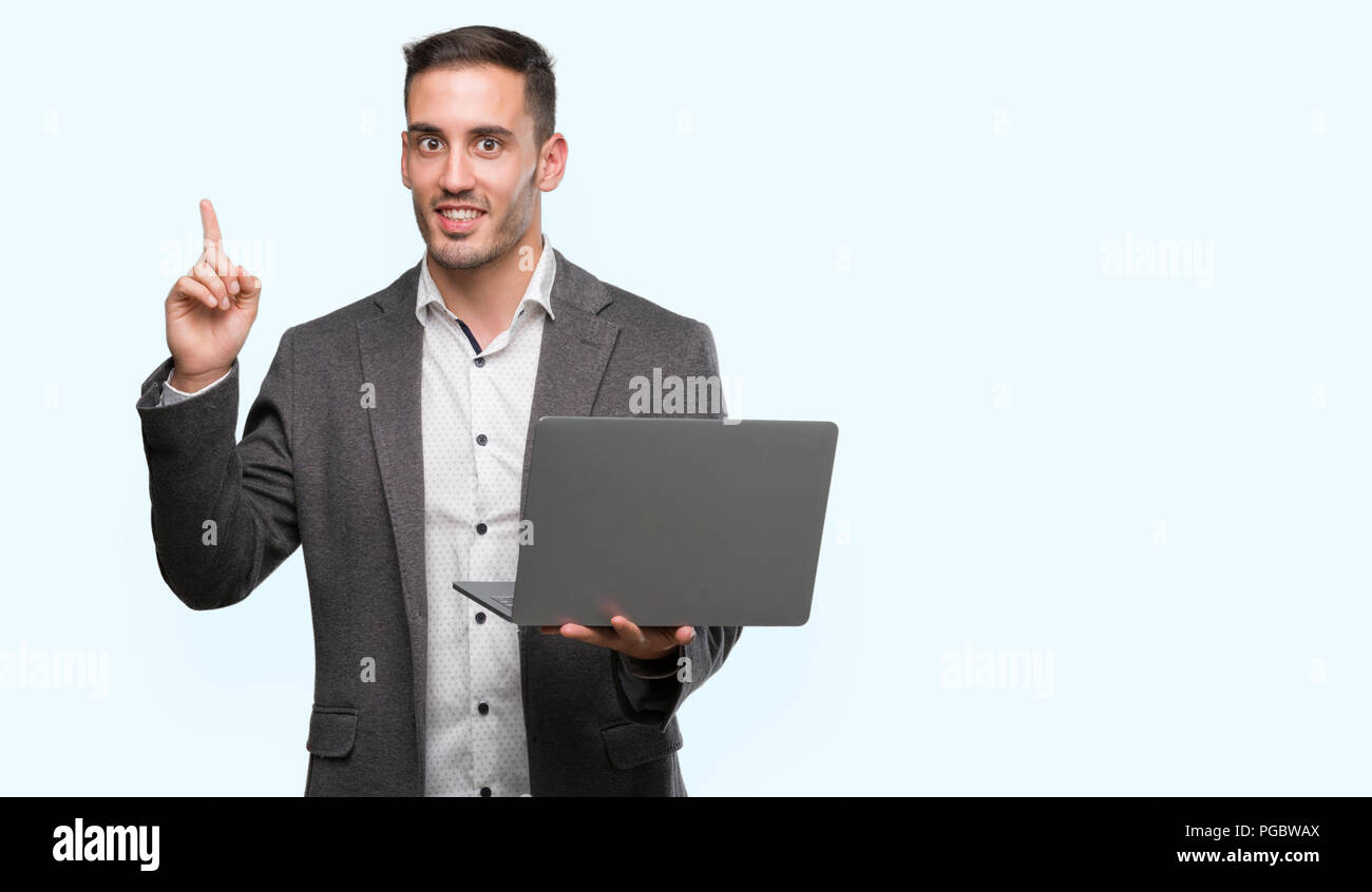 Handsome young man using computer laptop surprised with an idea or ...