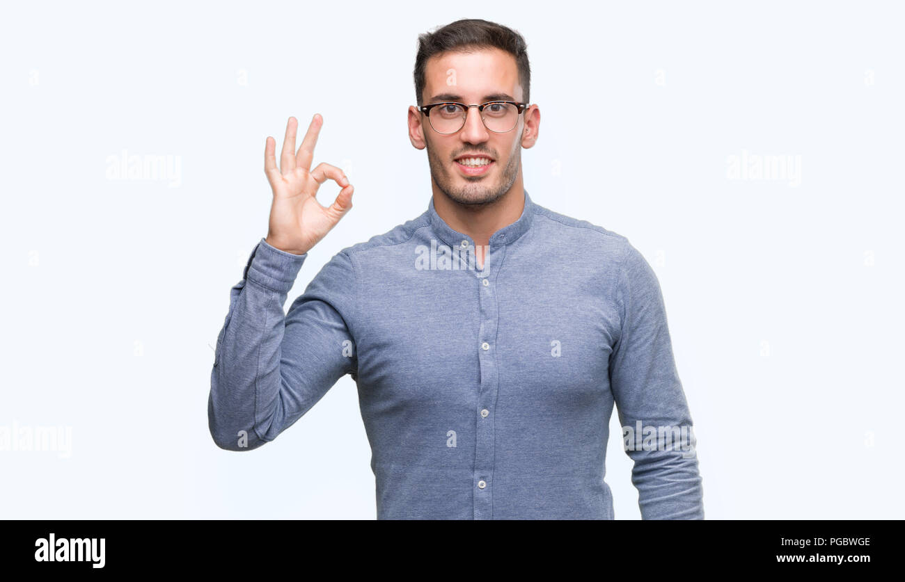 Handsome young elegant man wearing glasses smiling positive doing ok ...