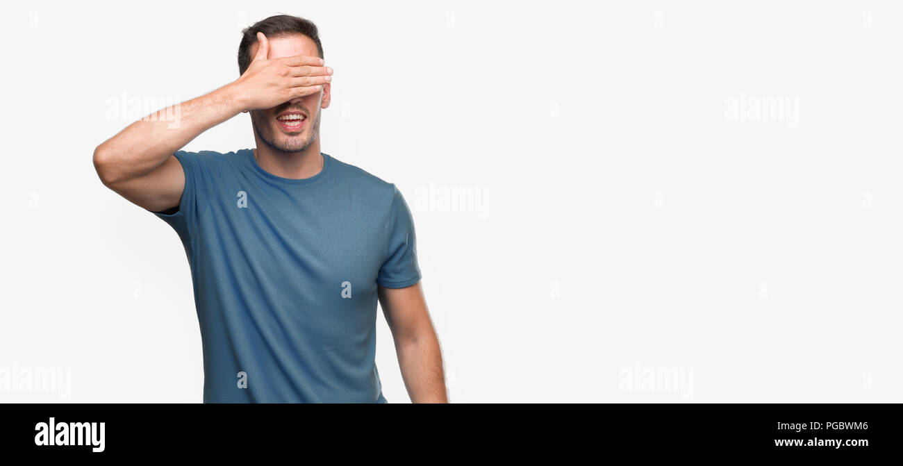 Handsome young casual man smiling and laughing with hand on face ...