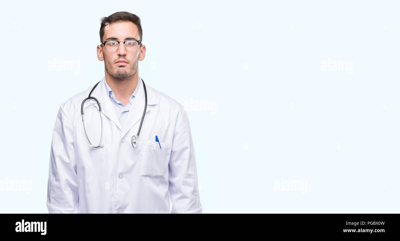 Handsome young doctor man with serious expression on face. Simple and ...