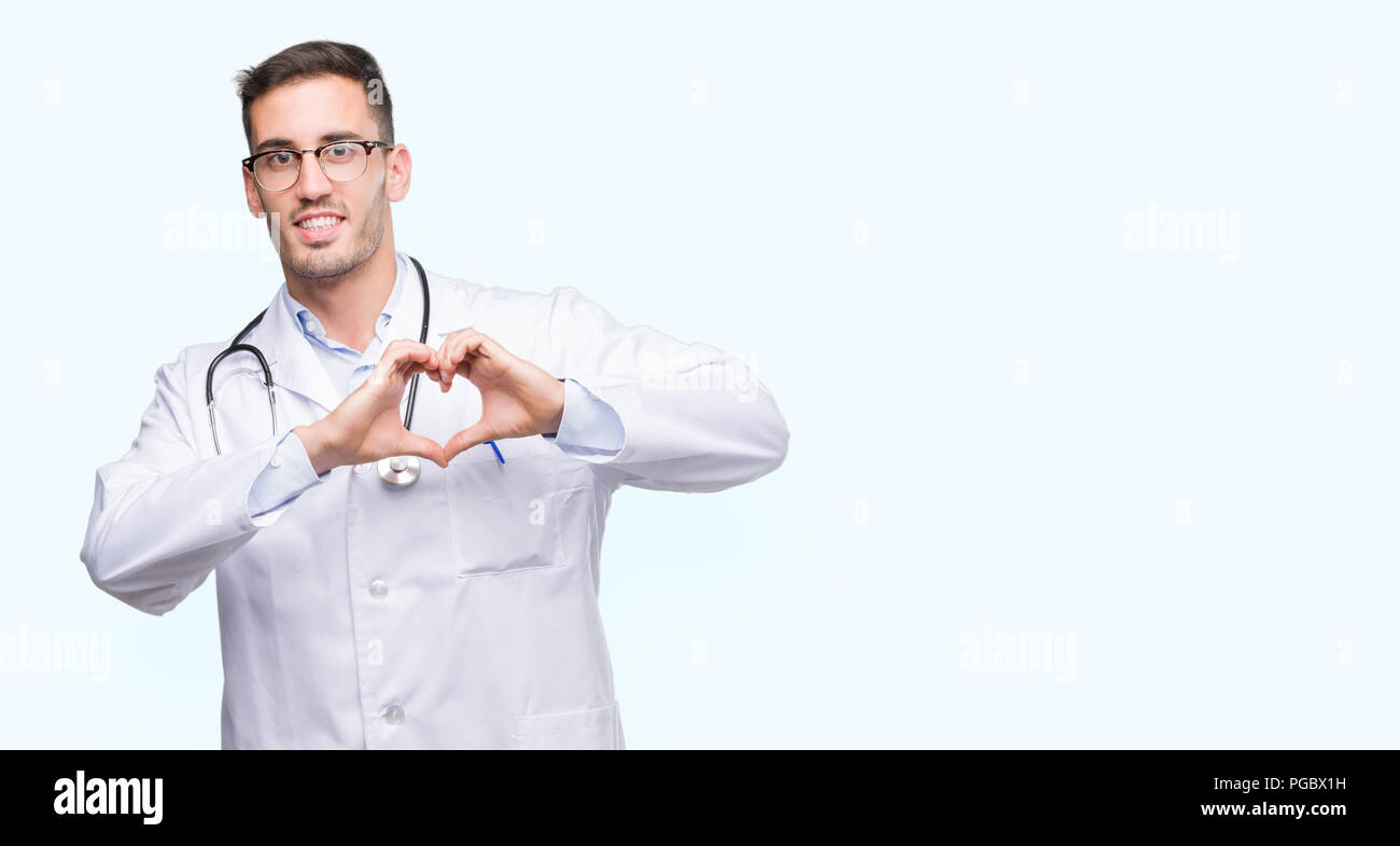 Handsome young doctor man smiling in love showing heart symbol and ...