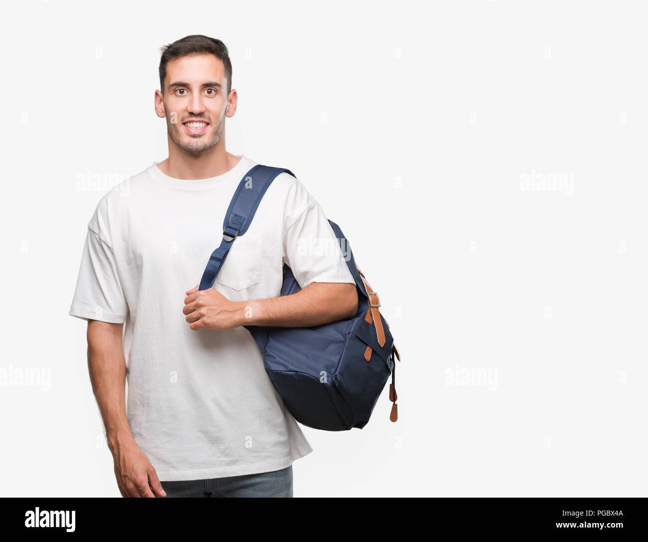 Handsome young man holding backpack with a happy face standing and ...