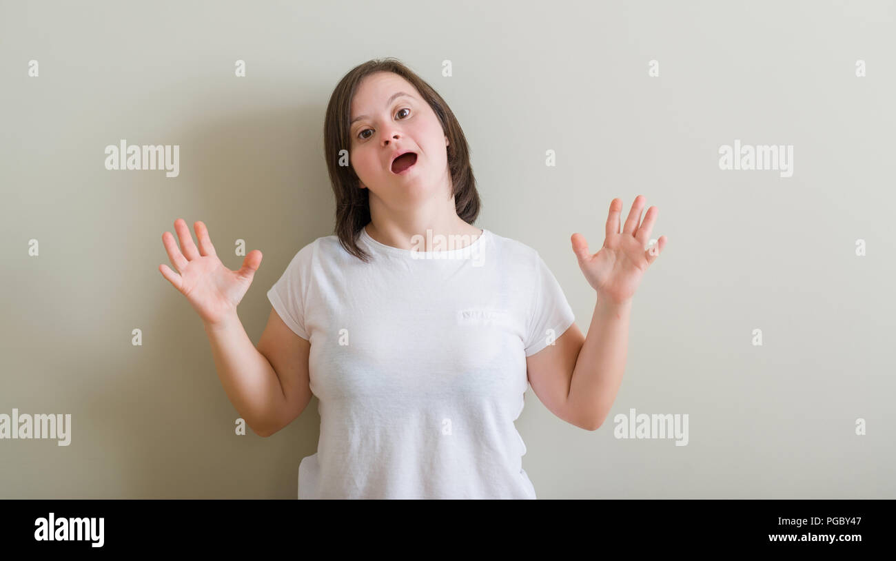 Down syndrome woman standing over wall crazy and mad shouting and ...