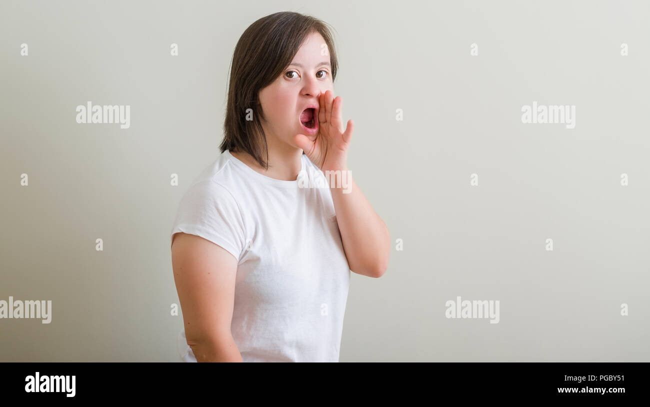 Down syndrome woman standing over wall shouting and screaming loud to ...