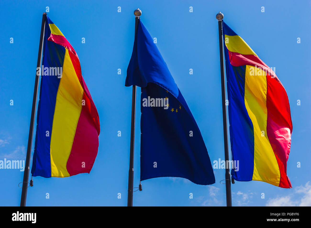 Romanian and EU flags waving on background of blue sky Stock Photo - Alamy